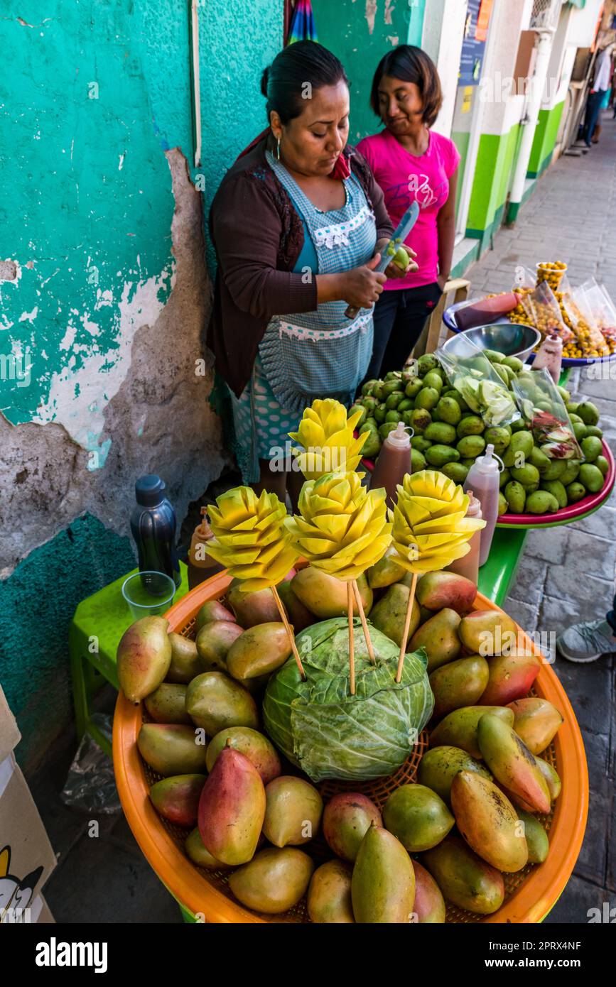Women selling fresh mangoes on the street in Tlacolula de Matamoros in ...