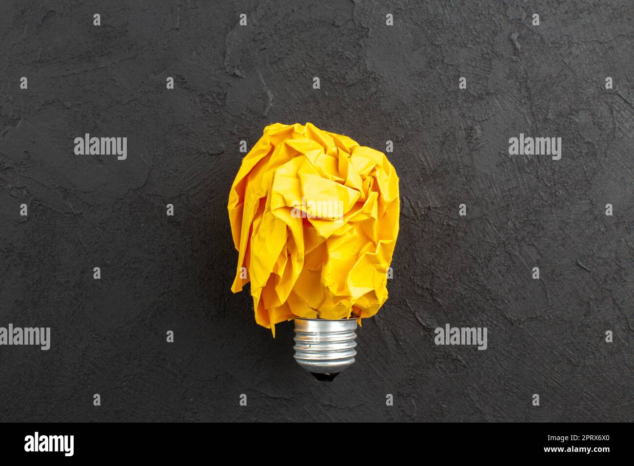 top view light bulb wrapped with paper on black table with free space ...