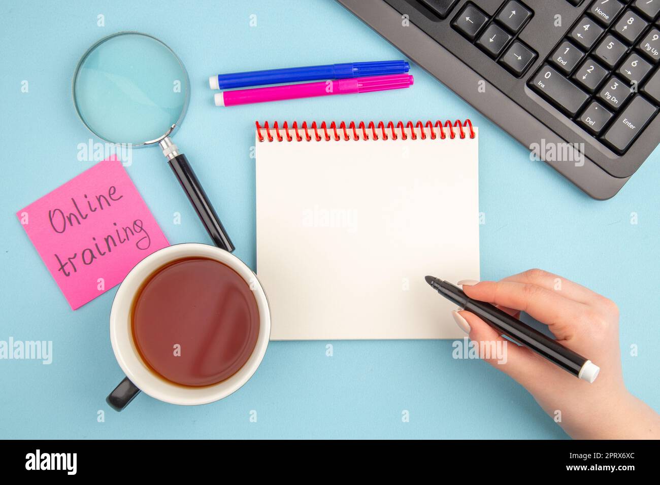 top view online training written on sticky note cup of tea marker in ...
