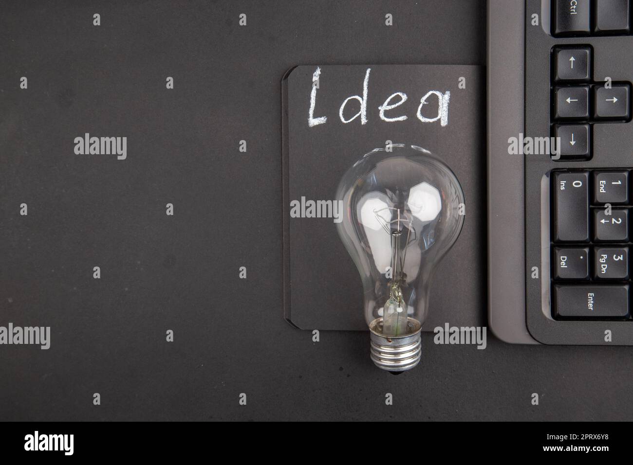 top view light bulb idea written on notepad keyboard on dark background ...