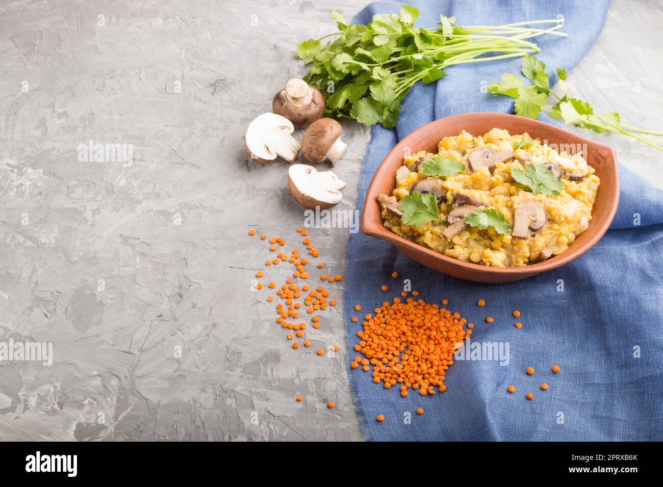 Lentils porridge with champignons and coriander in a clay bowl on a ...