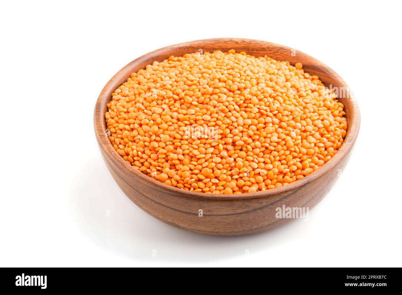 Raw uncooked lentils in a wooden bowl isolated on white background. Side view, flat lay, close ...