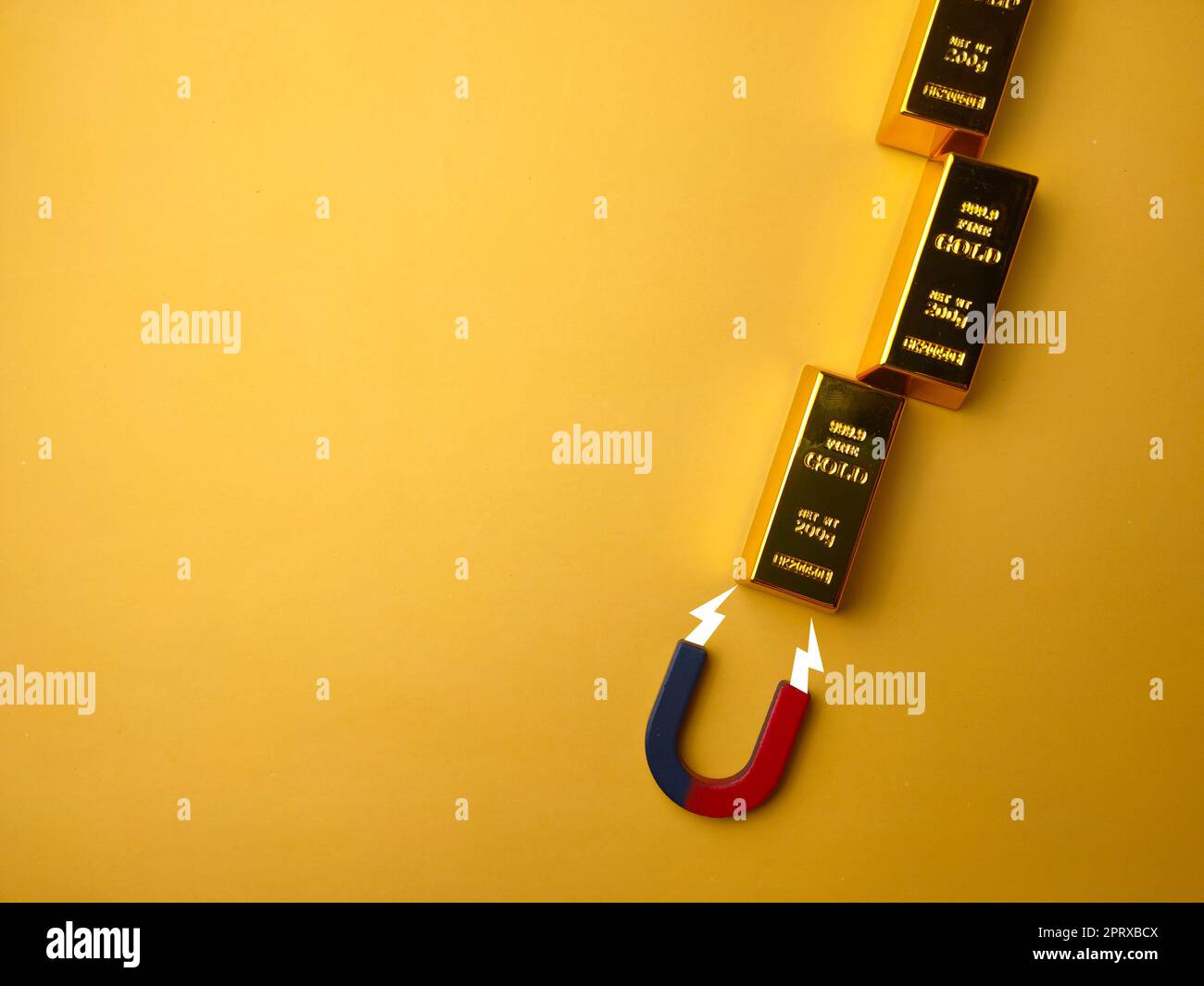 Top view magnet attract the gold bar on a yellow background Stock Photo ...