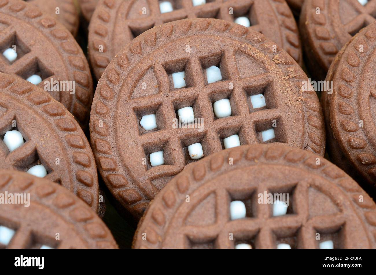 Detailed picture of dark brown round sandwich cookies with coconut ...