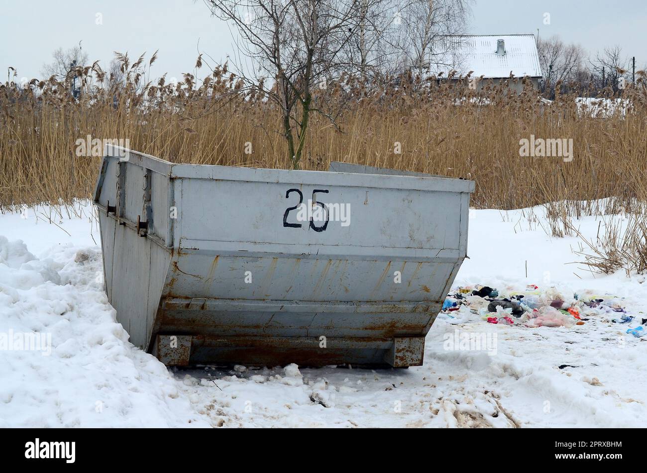 Trash bin at the side of street in winter with lip garbage container ...