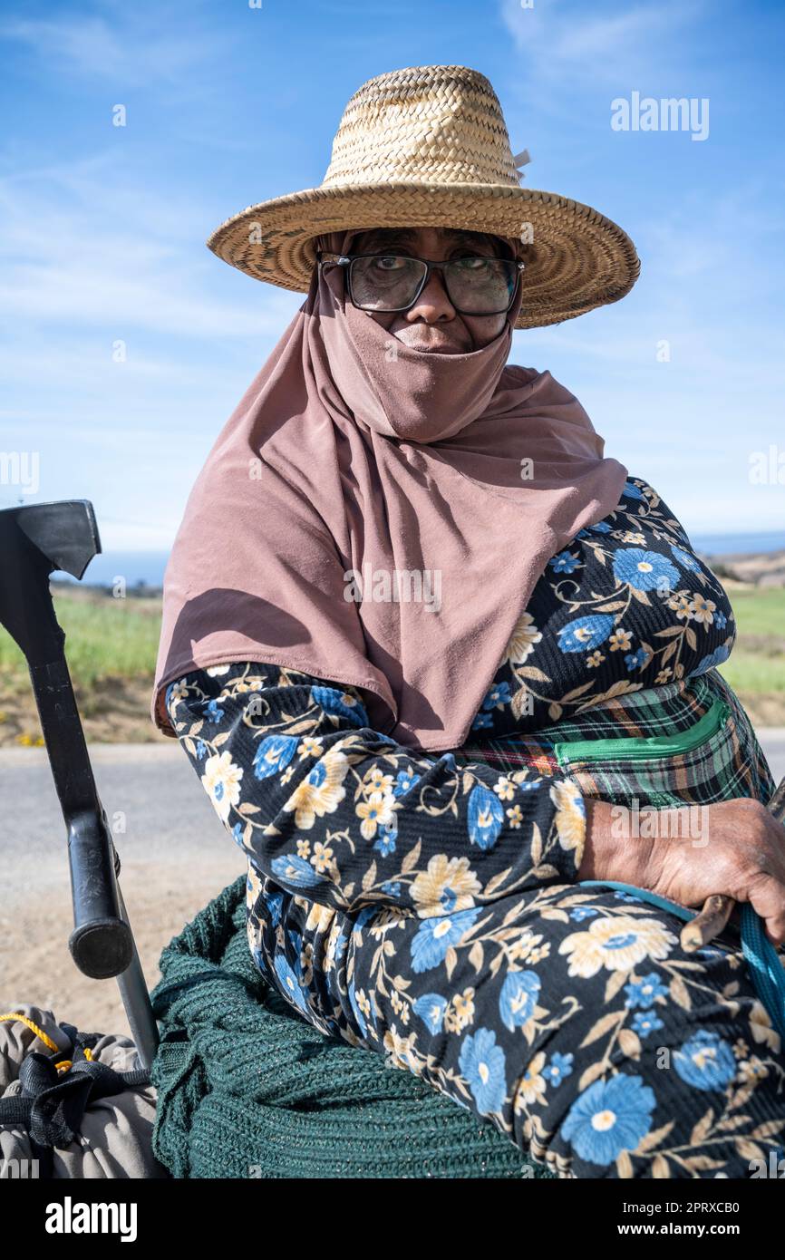 Woman with a straw hat and crutches riding a mule Stock Photo - Alamy