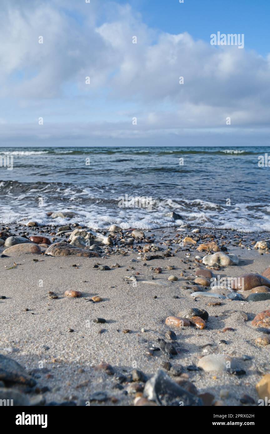 Stone beach on the coast of Denmark. Stones in the sand and in the ...