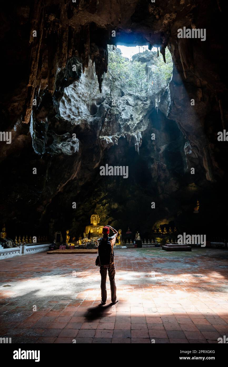 Light shines down in the Tham Khao Luang Cave on the beautiful golden ...