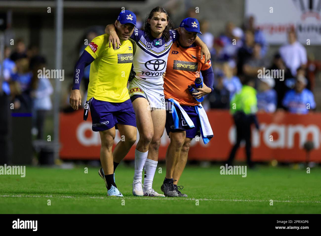 Tom Chester of the Cowboys is assisted off the field by trainers after ...
