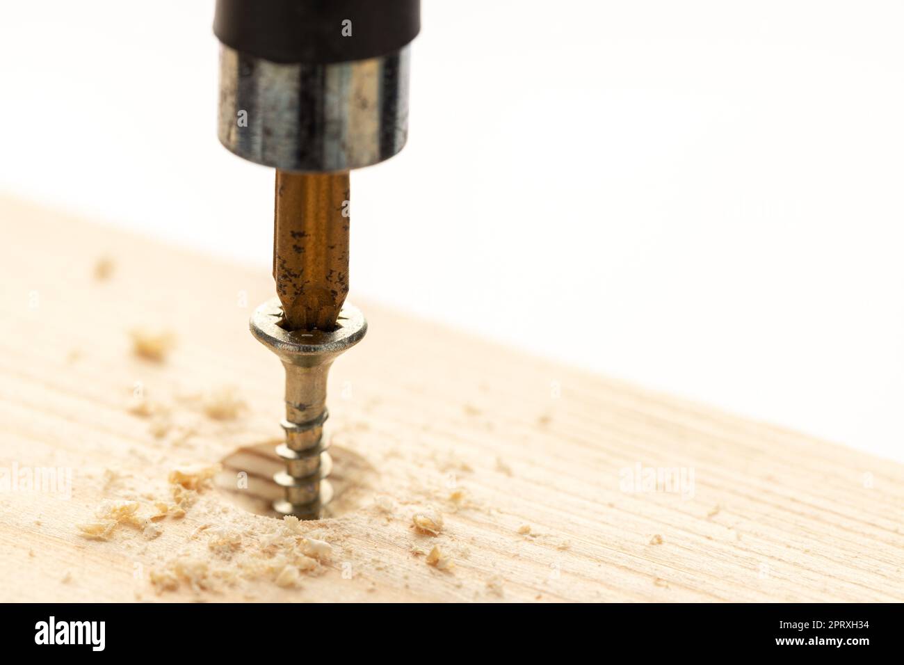 Screwdriver tightening a screw in a wood piece. Copy space Stock Photo ...