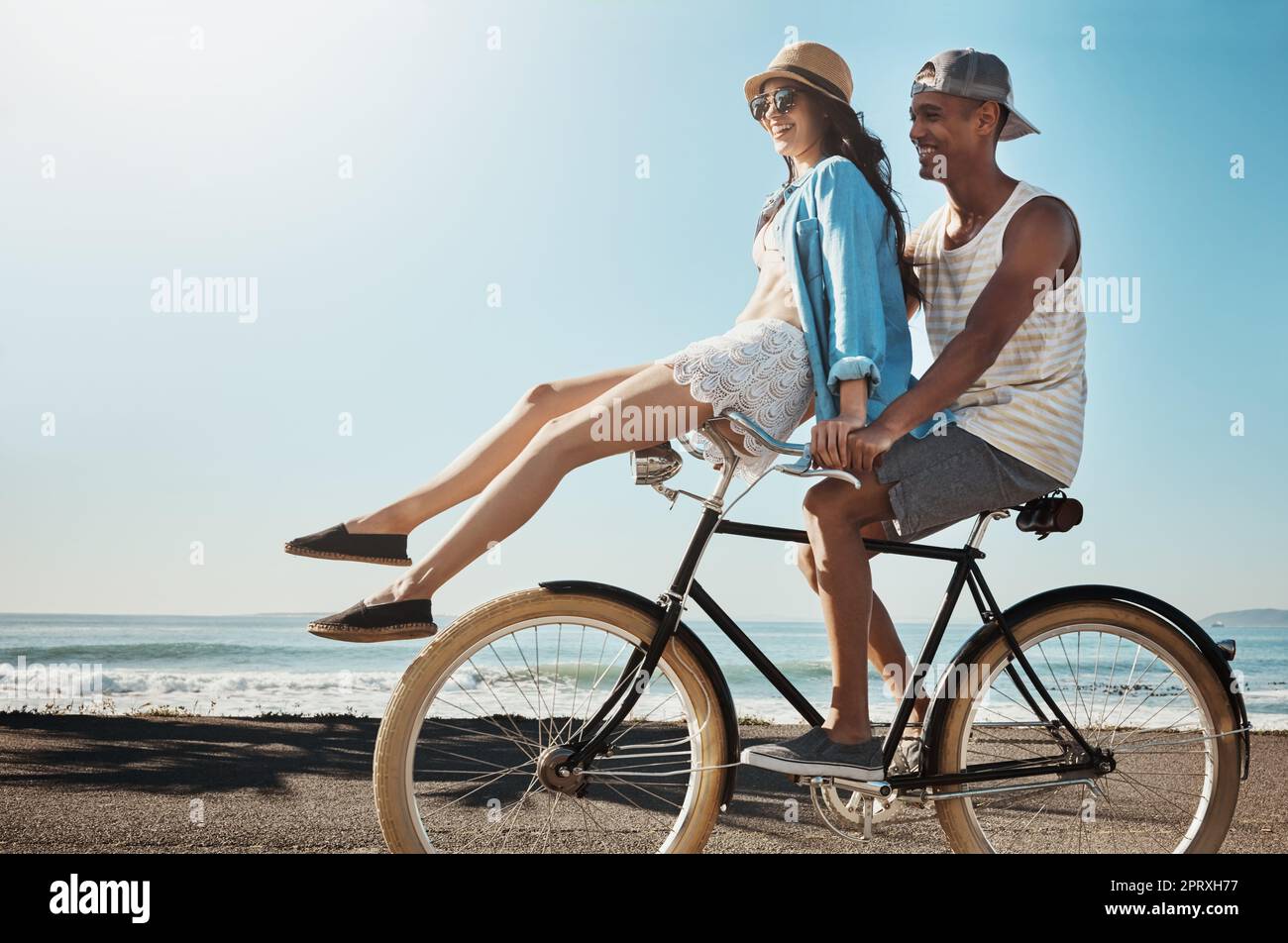 Theyre just cool like that. a young couple riding a bicycle together on ...
