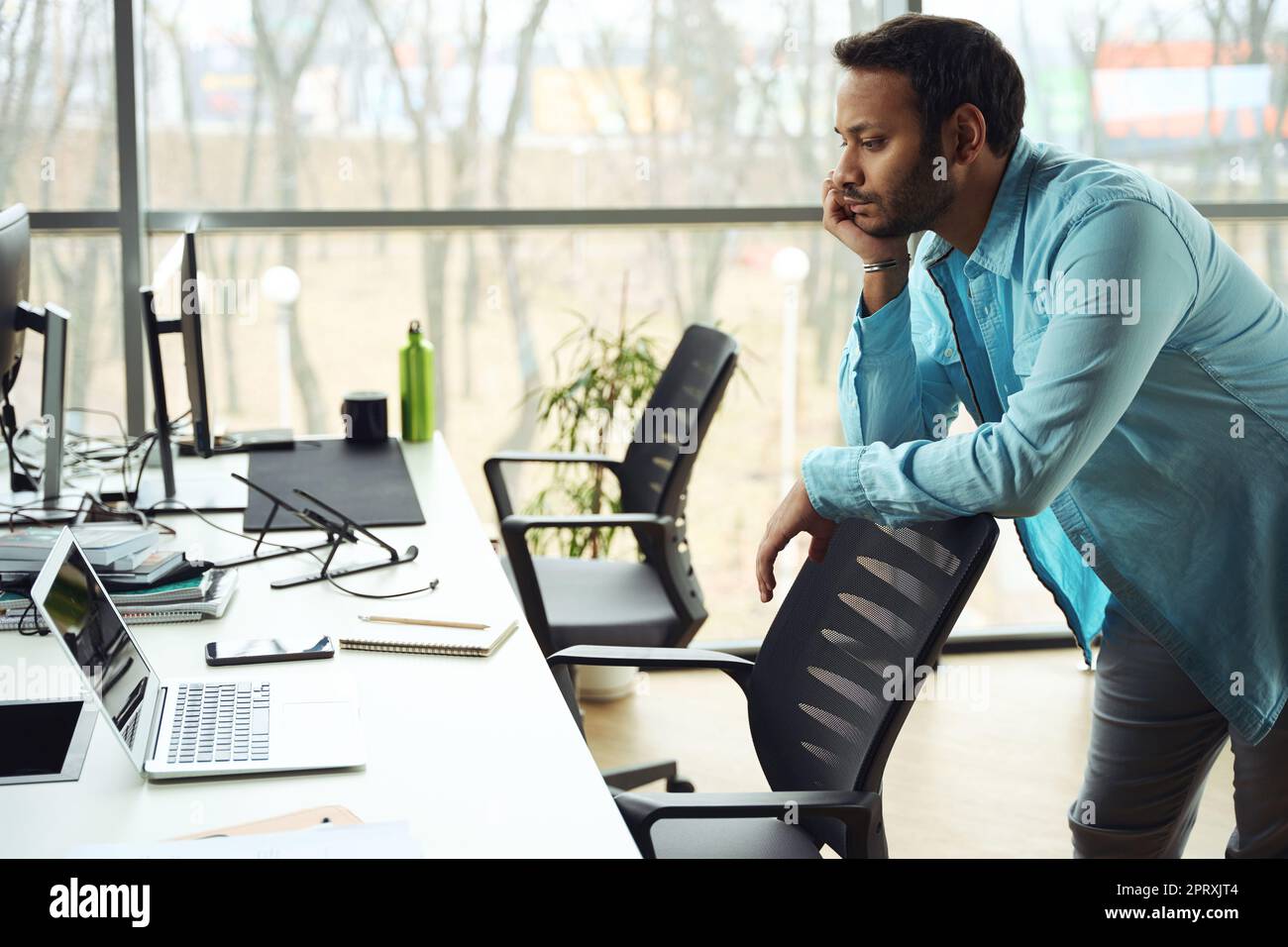 Man leaning on chair in the office Stock Photo - Alamy