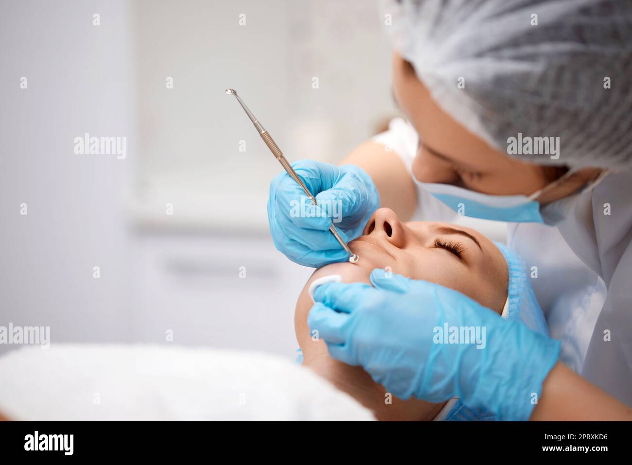 young woman during a mechanical face cleansing procedure at beauty ...