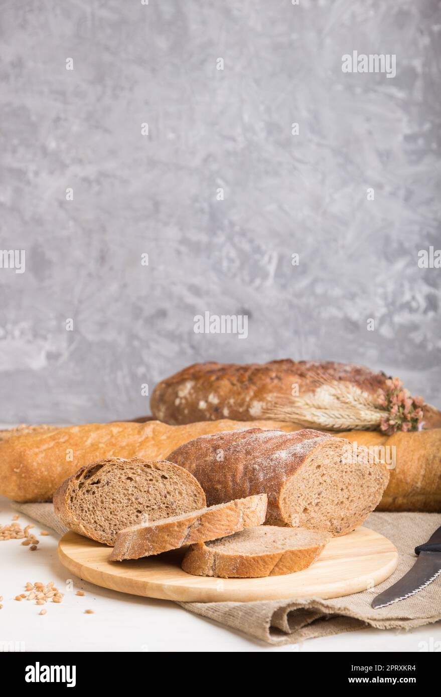 Sliced bread with different kinds of fresh baked bread on a gray ...