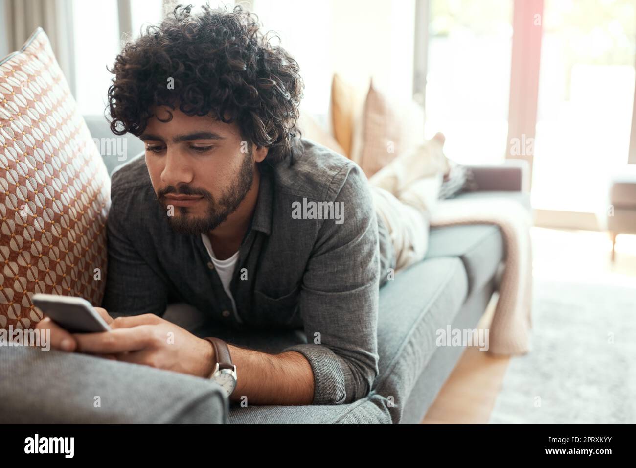 Chilling on my free time. a handsome young man using his cellphone ...