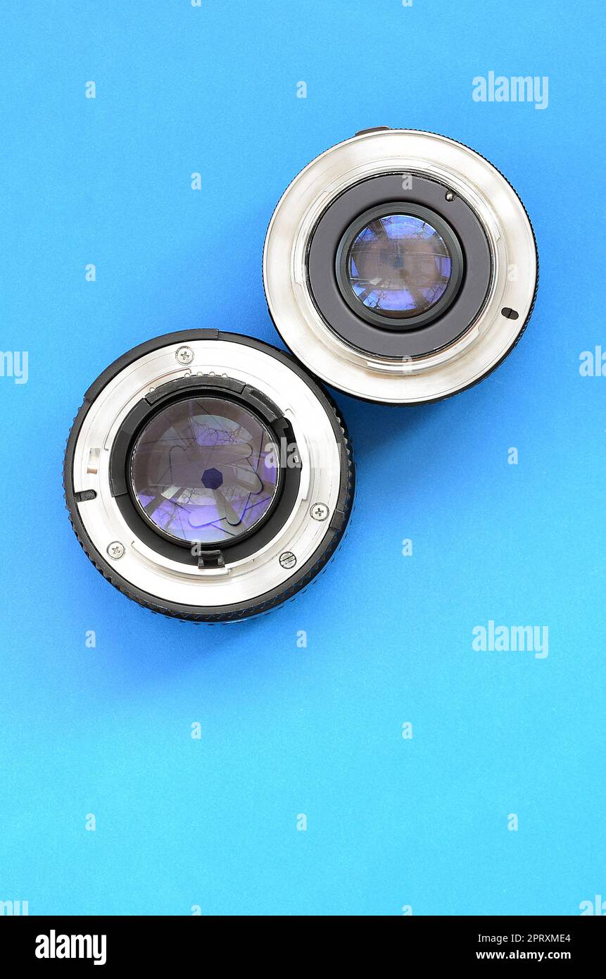 Two photographic lenses lie on a bright blue background. Space for text ...