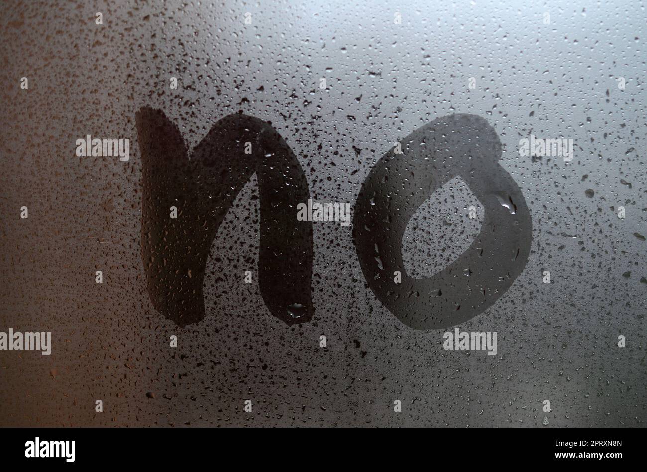 The English word "No" is written with a finger on the surface of the ...
