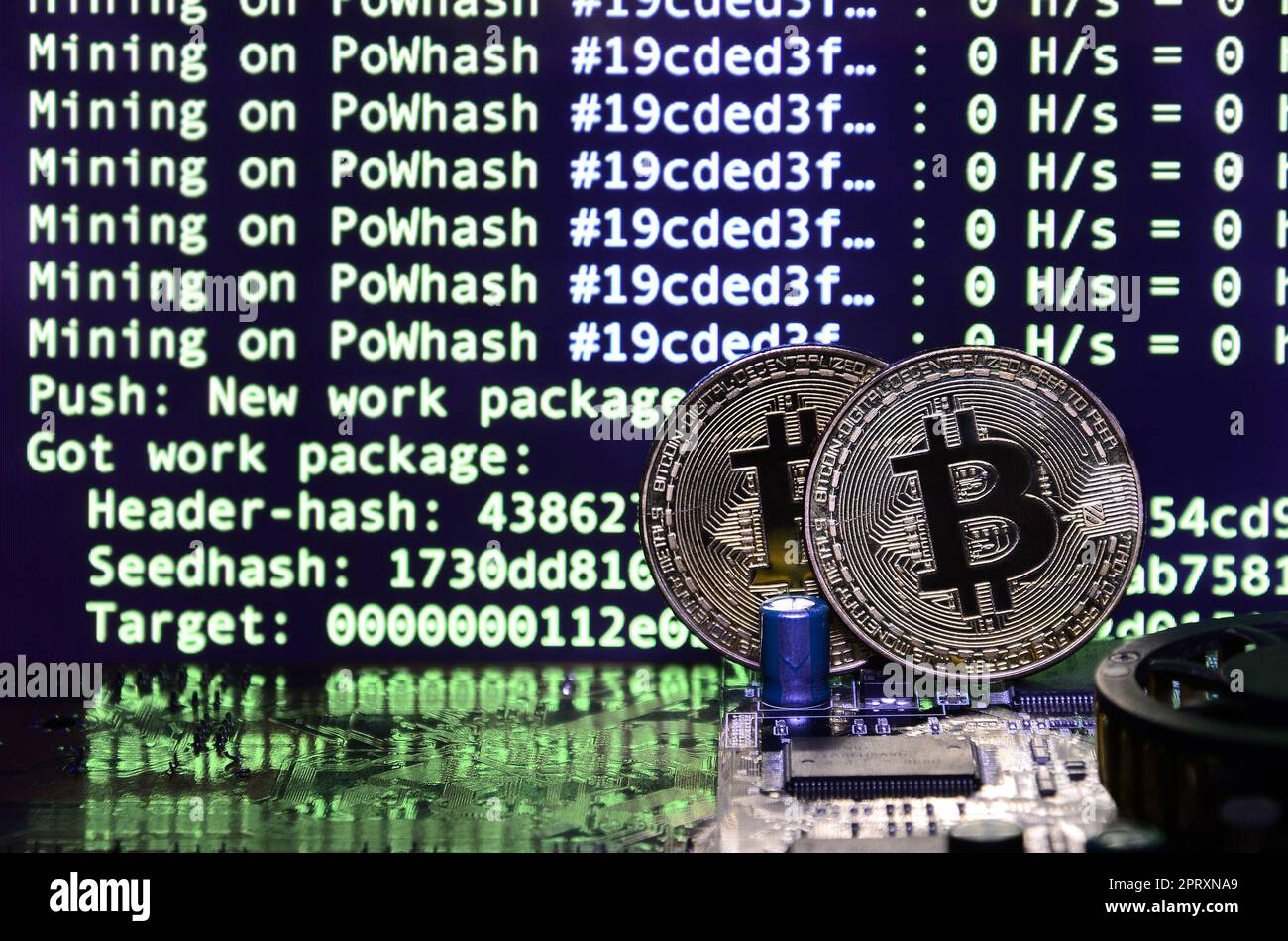 Two bitcoins lies on a videocard surface with background of screen ...
