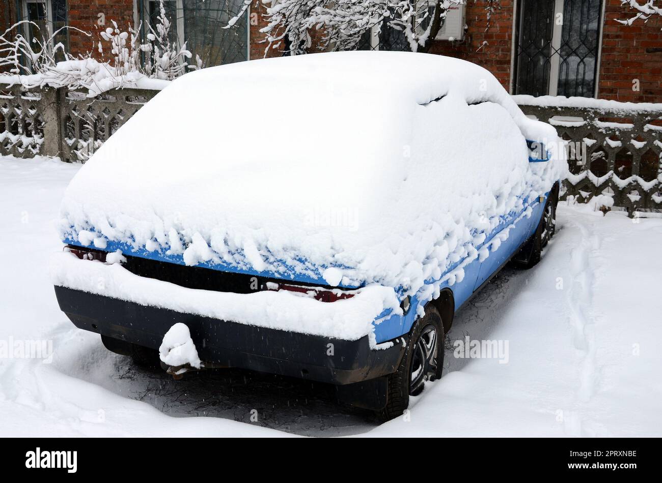 Photo of a car covered in a thick layer of snow. Consequences of heavy ...