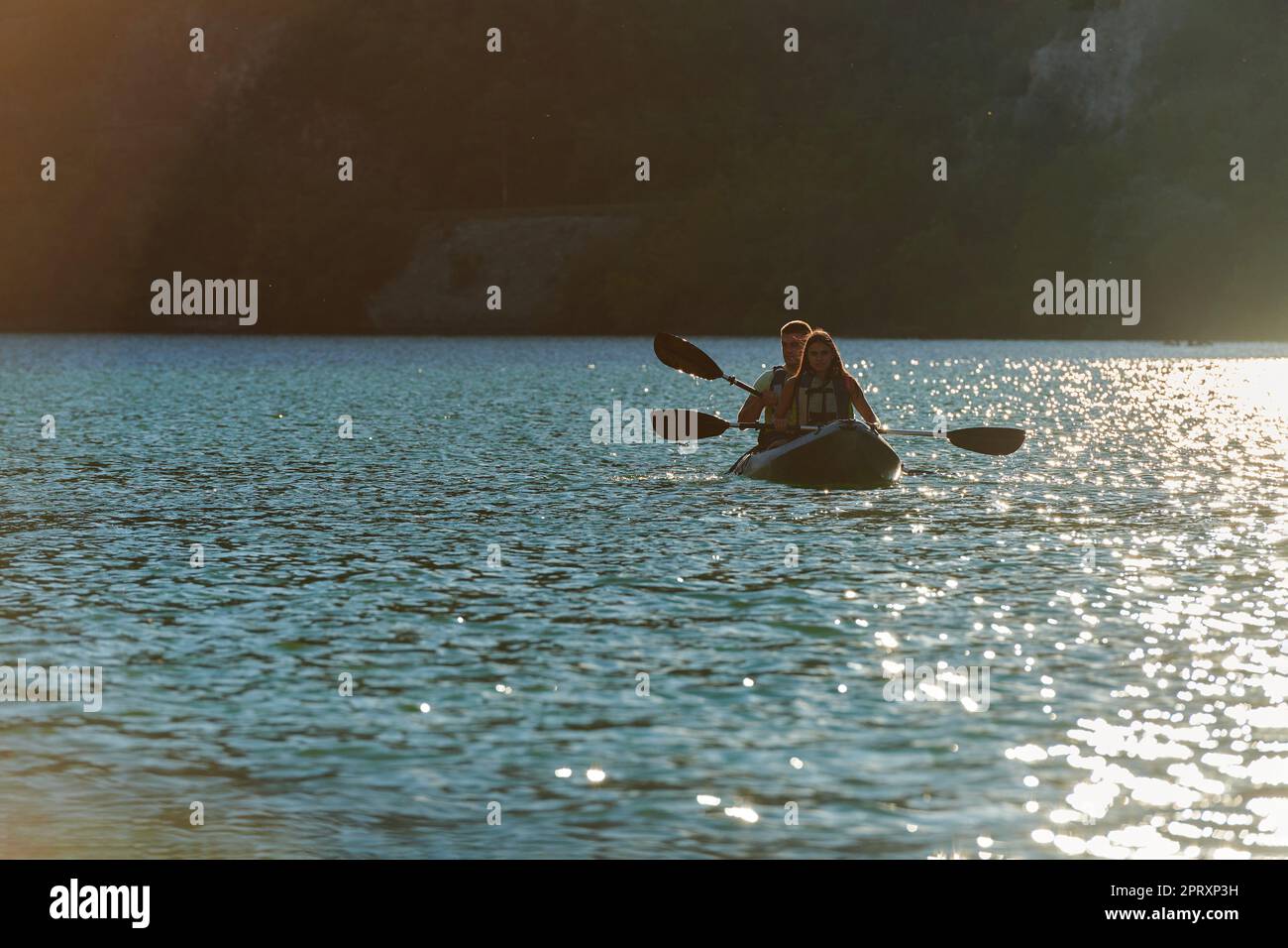 A young couple enjoying an idyllic kayak ride in the middle of a ...