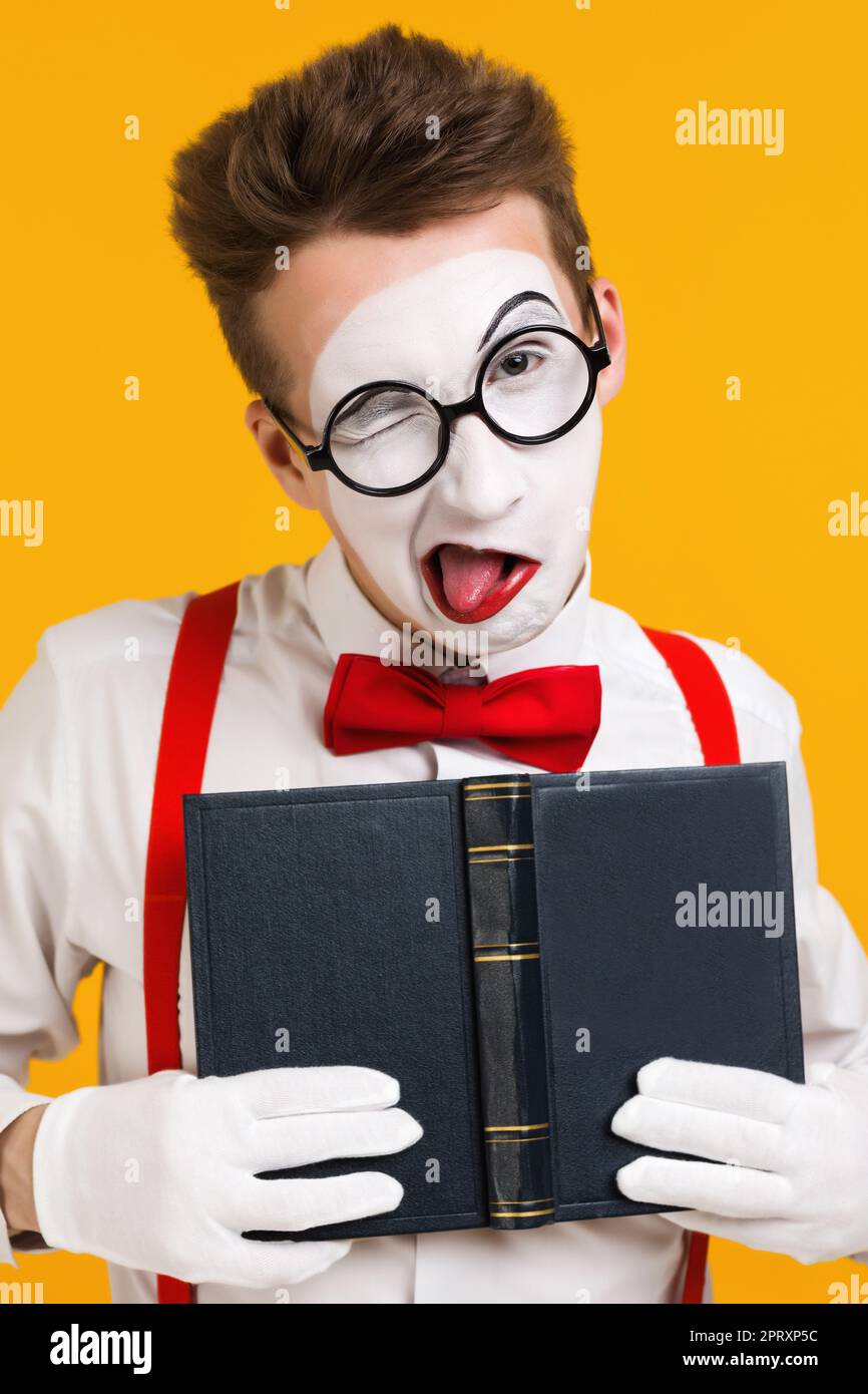 portrait of mime man artist with book ape isolated on yellow background ...