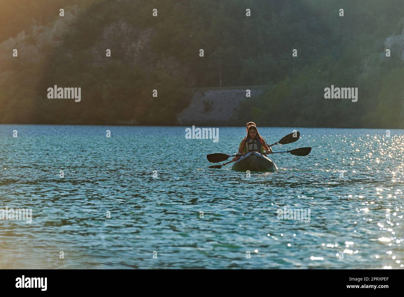 A young couple enjoying an idyllic kayak ride in the middle of a ...
