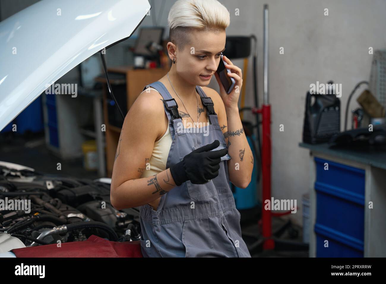 Female at workplace in auto repair shop talking on phone Stock Photo ...