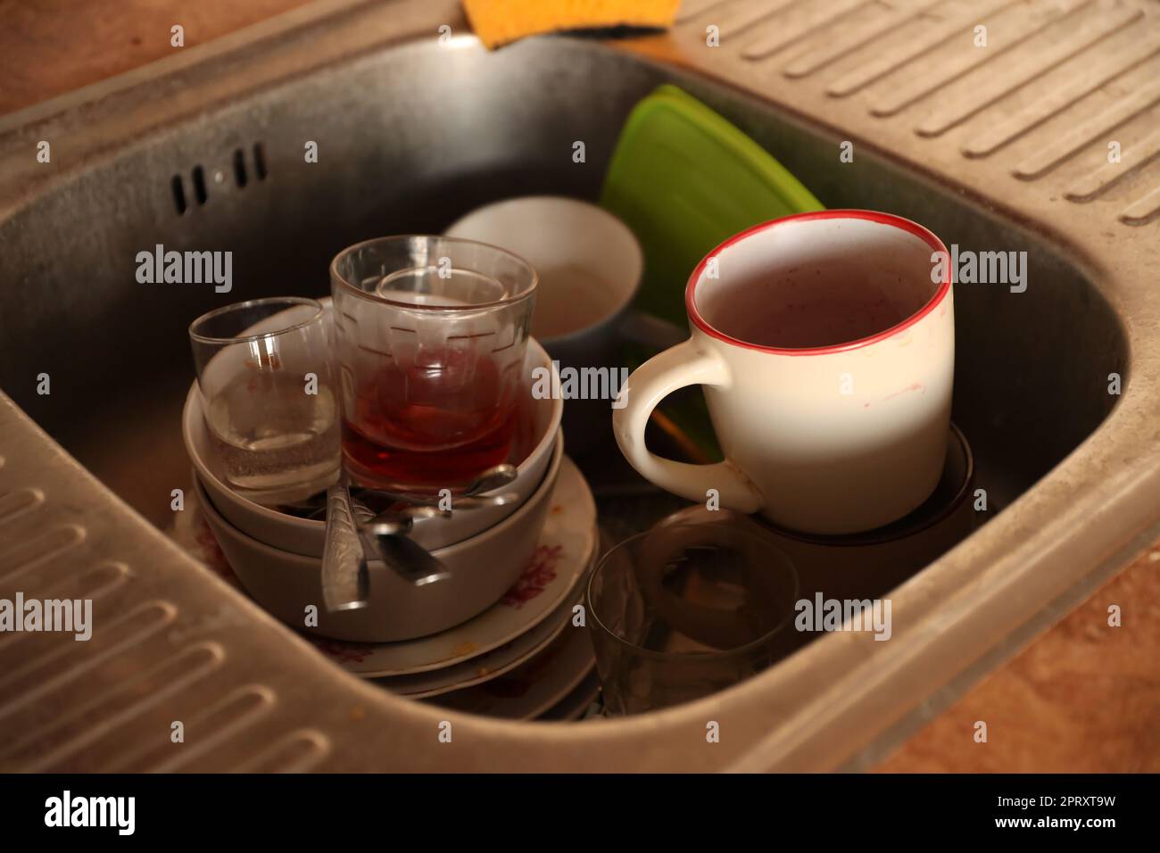 Stack of dirty dishes with food leftovers in the kitchen sink. Unwashed ...