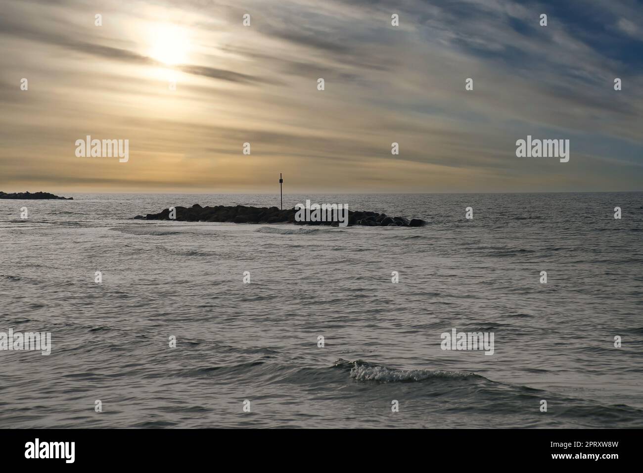 Stone groynes, breakwaters in the water off the coast in Denmark. In ...