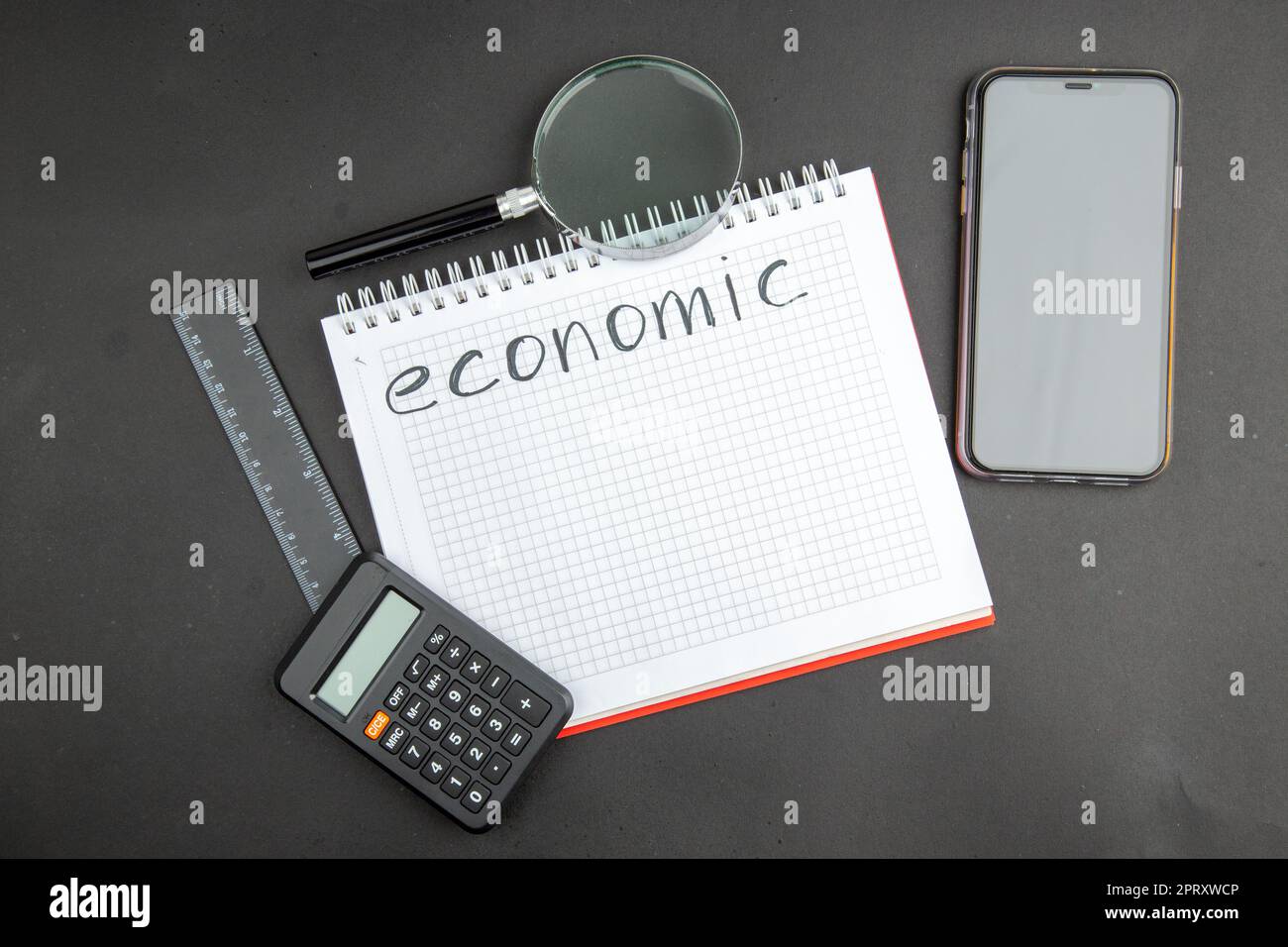 top view economic written on spiral notebook lupa calculator phone ...
