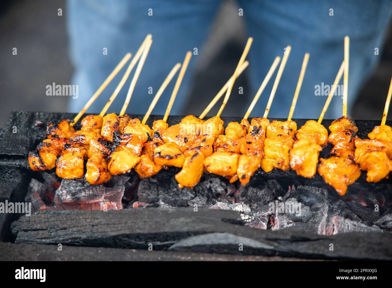 Closeup of chicken satay being barbecue with traditional pit and fired ...