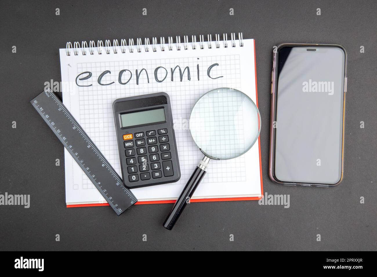 top view economic written on spiral notepad lupa calculator phone ruler ...