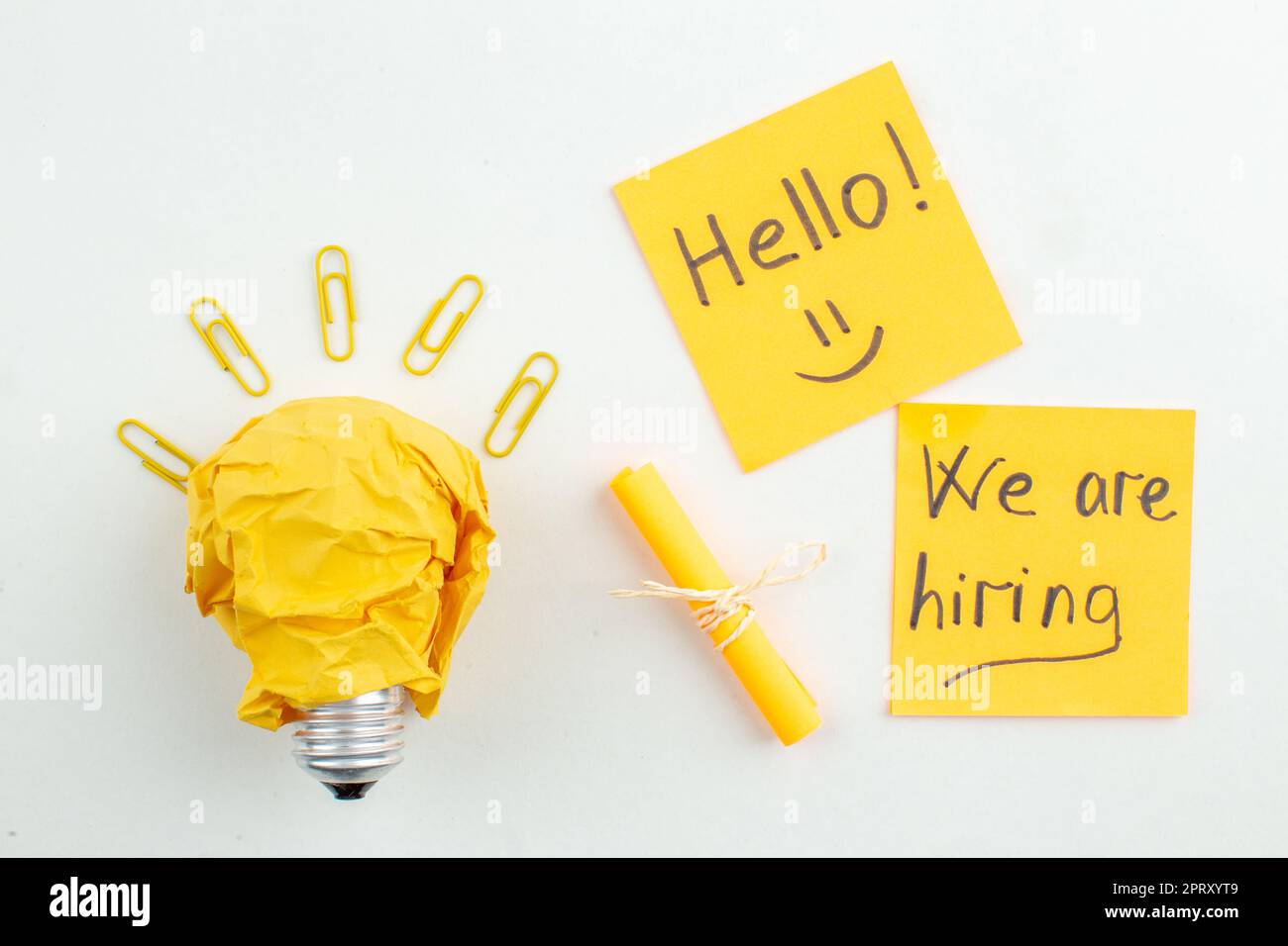 top view hello and we are hiring written on sticky notes idealight bulb ...