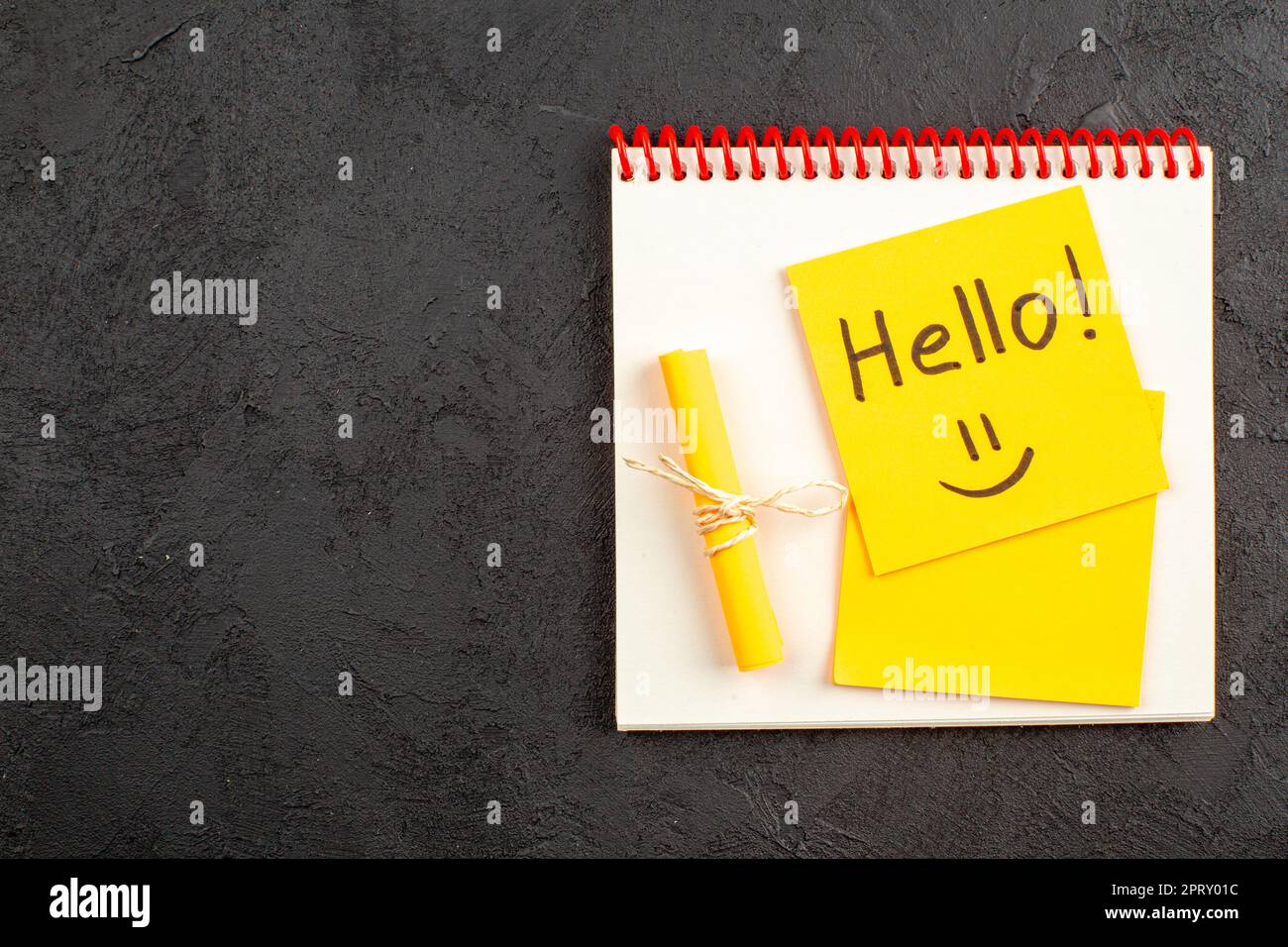 top view hello written on sticky note on notepad rolled up note paper ...