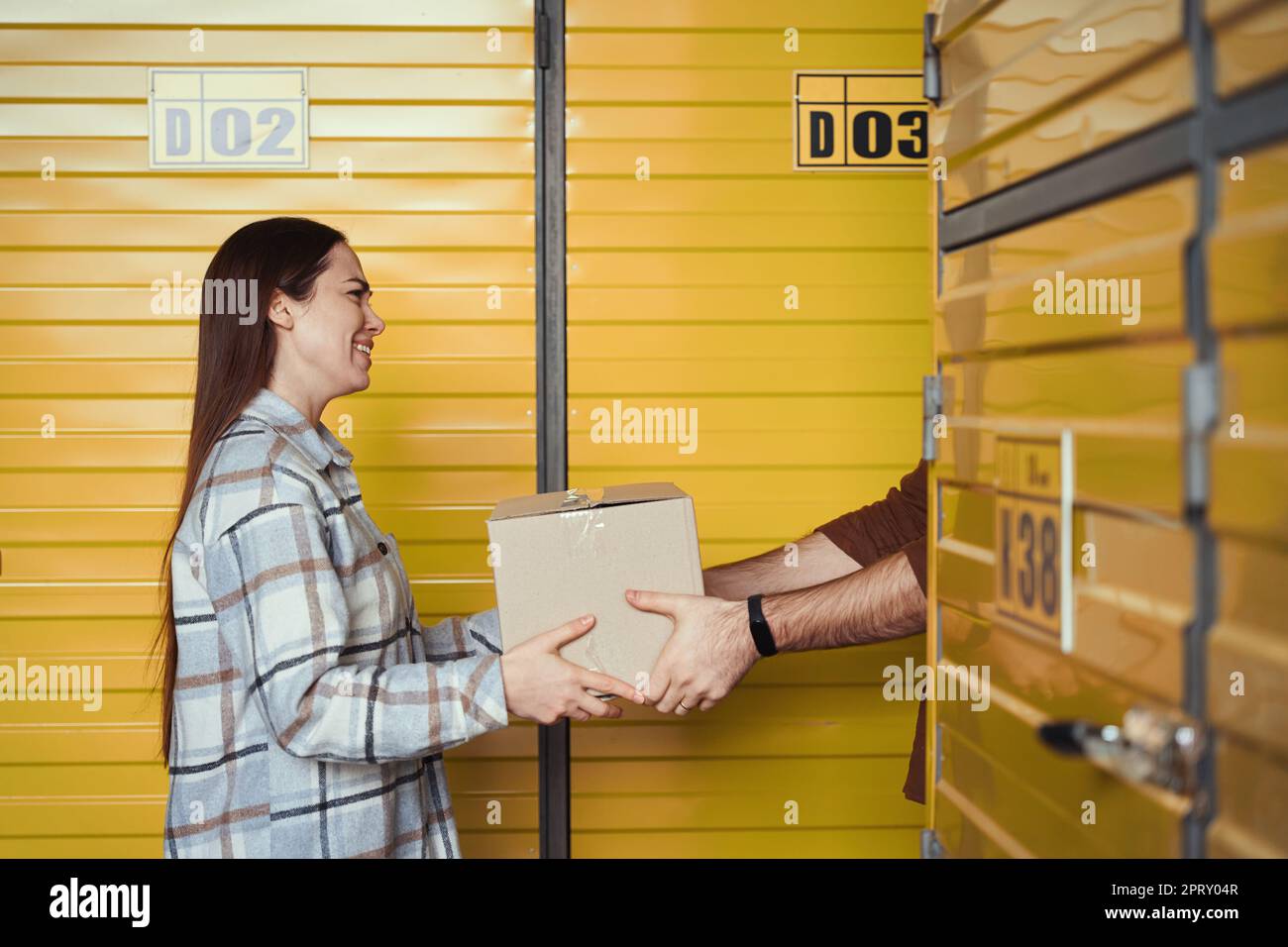 Frustrated young woman passing the box into man hands Stock Photo - Alamy