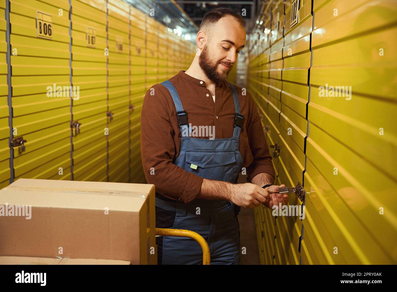 Focused young male using the locker lock in the warehouse Stock Photo ...