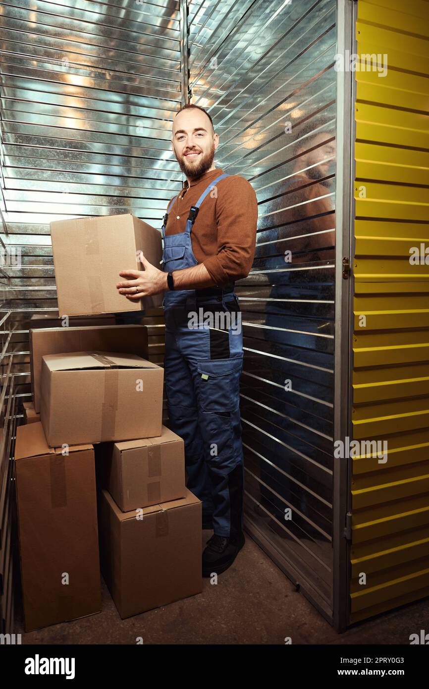 Happy young man holding box in the warehouse Stock Photo - Alamy
