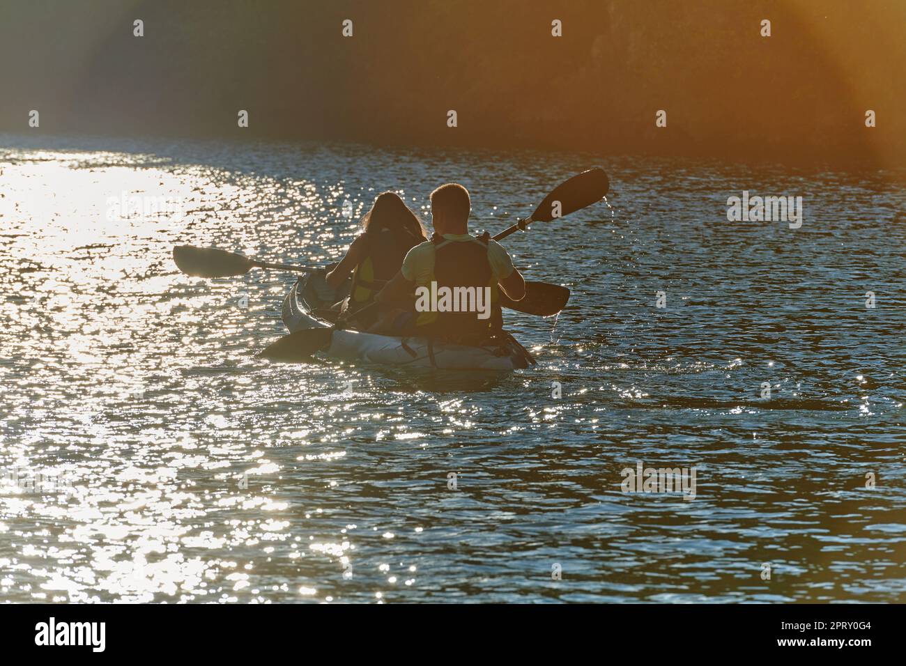 A young couple enjoying an idyllic kayak ride in the middle of a ...