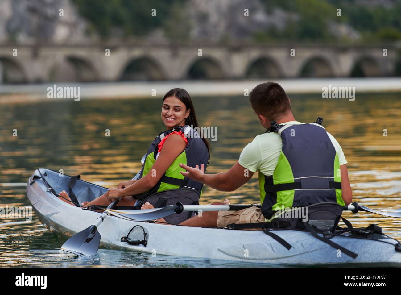 A young couple enjoying an idyllic kayak ride in the middle of a ...