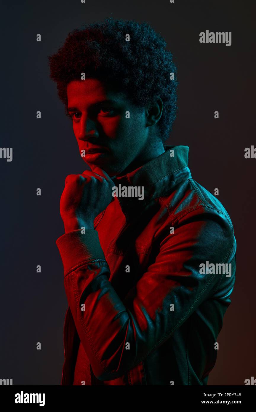 Portrait of young stylish man wearing fashion jacket in neon red over ...