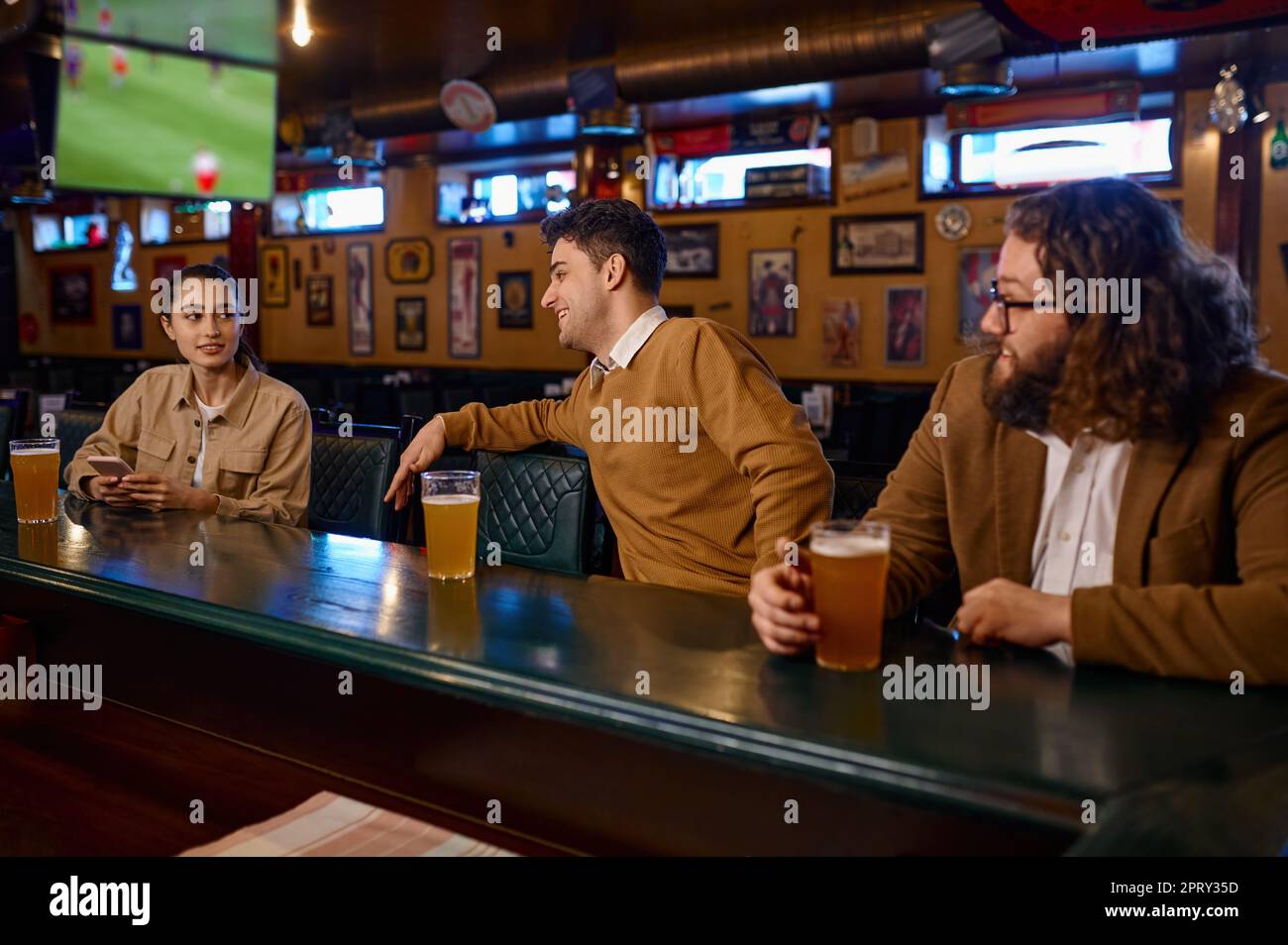 Young male friends flirting with woman at bar counter. People having ...