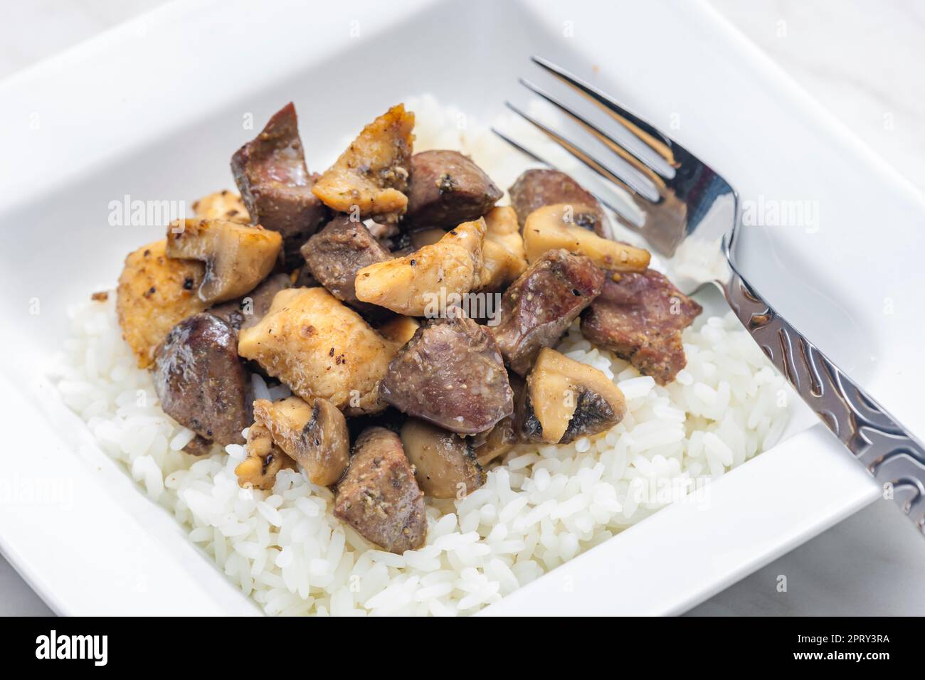 mixture of fried livers, poultry meat and champignons served with rice ...