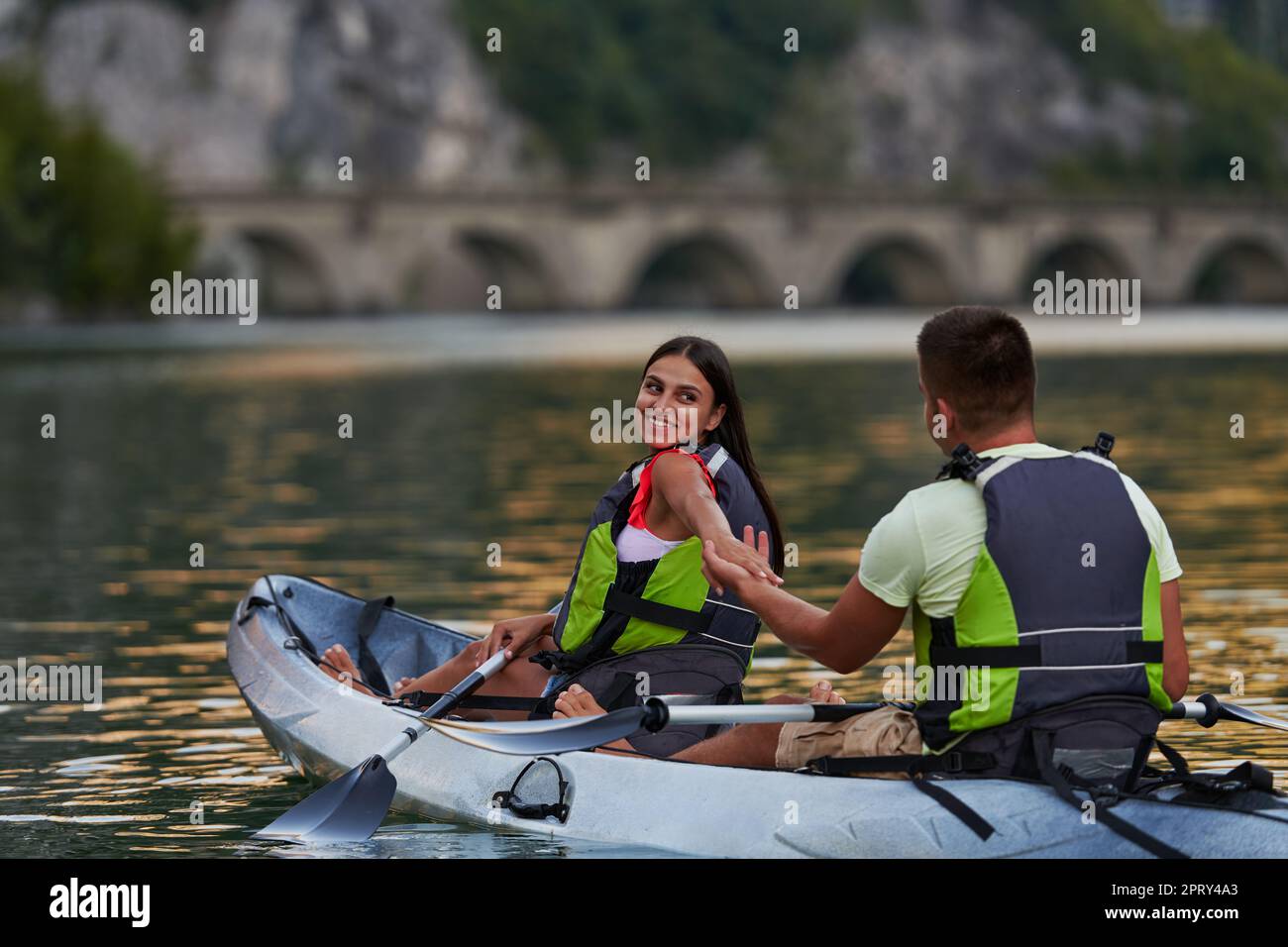 A young couple enjoying an idyllic kayak ride in the middle of a ...