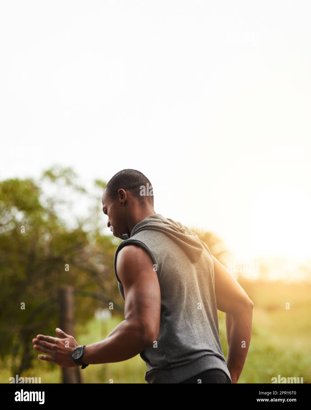 Powering through the fatigue. a healthy young man out for a run in ...