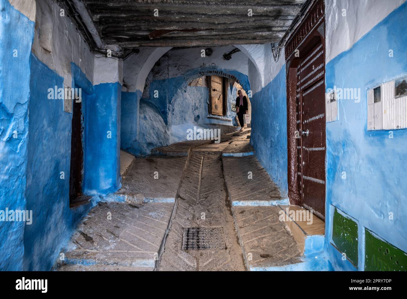 Woman going down the stairs of a steep alley in the medina of Tetouan ...