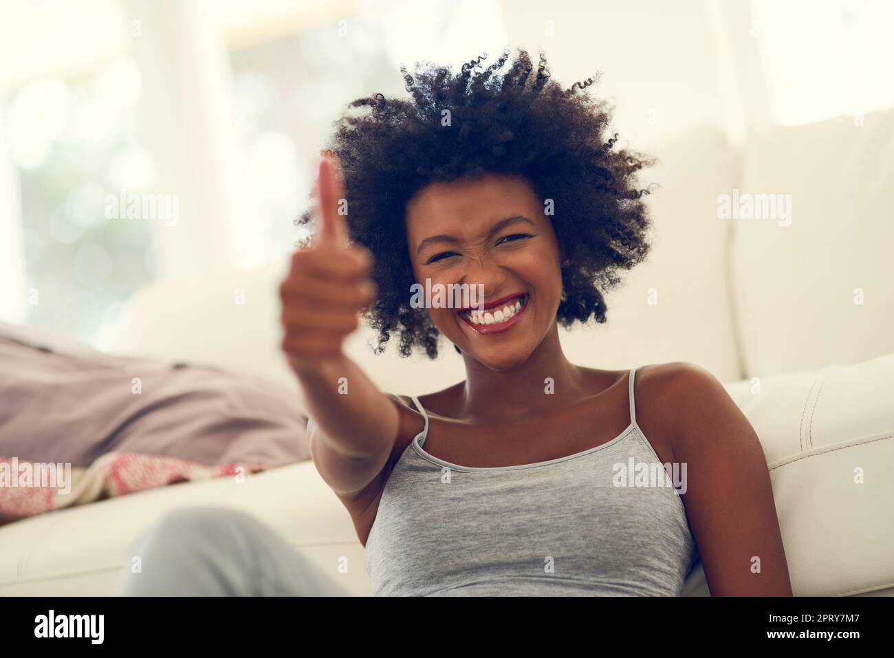 Its all about the good times. Portrait of a young woman showing thumbs ...