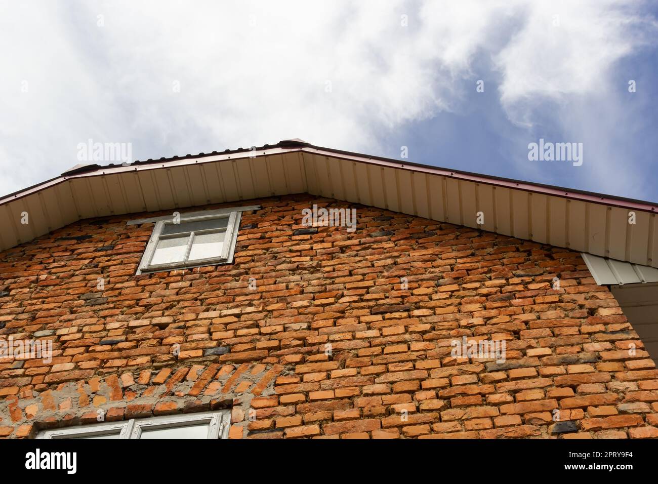 Red brick wall with windows. Bottom view on the background of the sky ...