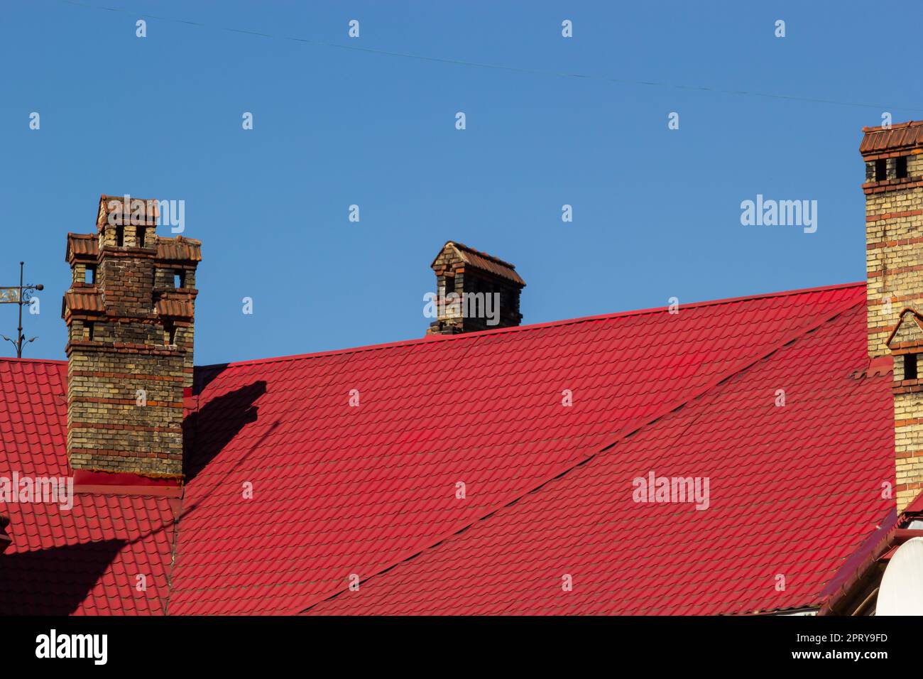 red brick chimney in the top of the village house. A roof made of tiles ...