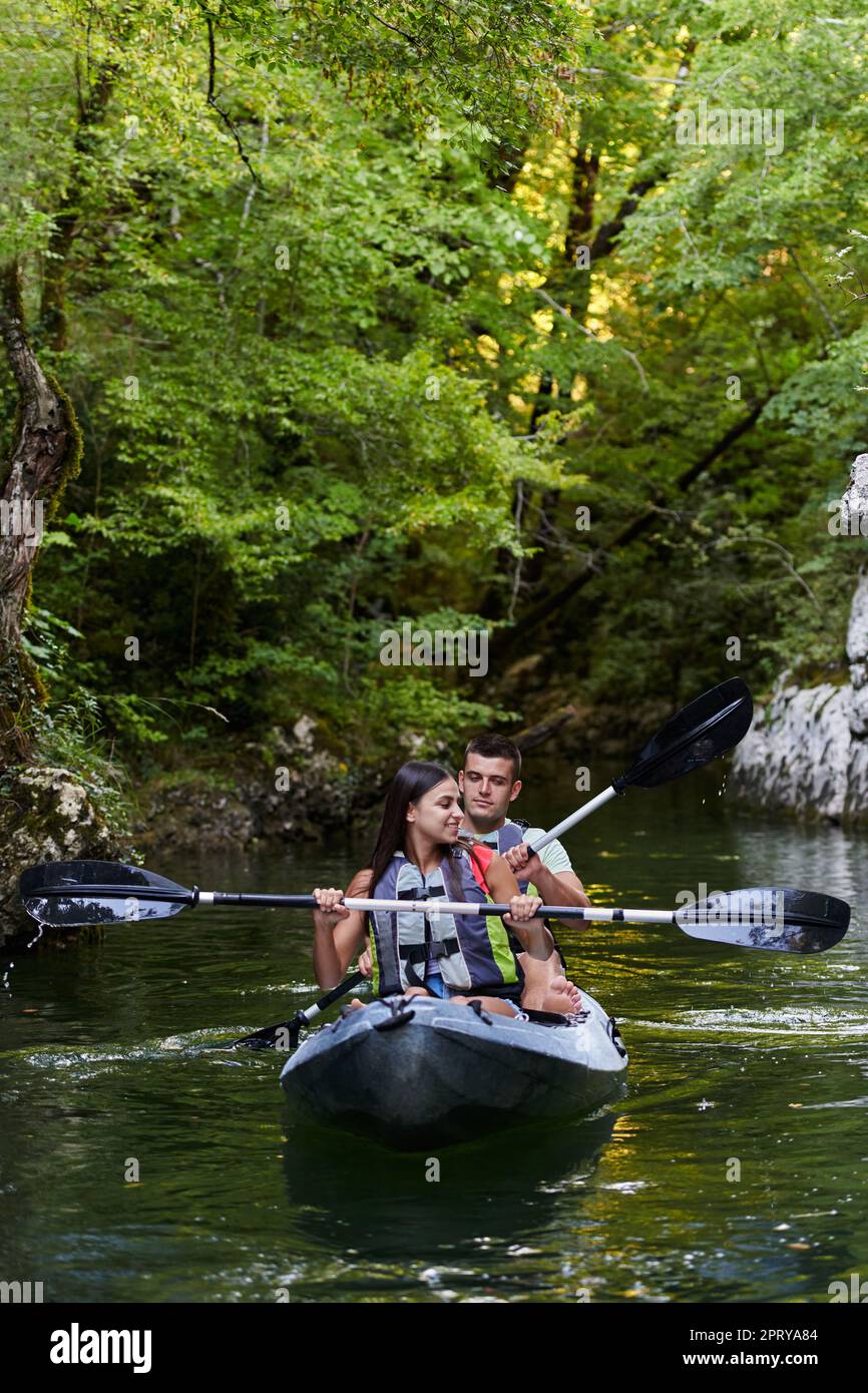 A young couple enjoying an idyllic kayak ride in the middle of a ...