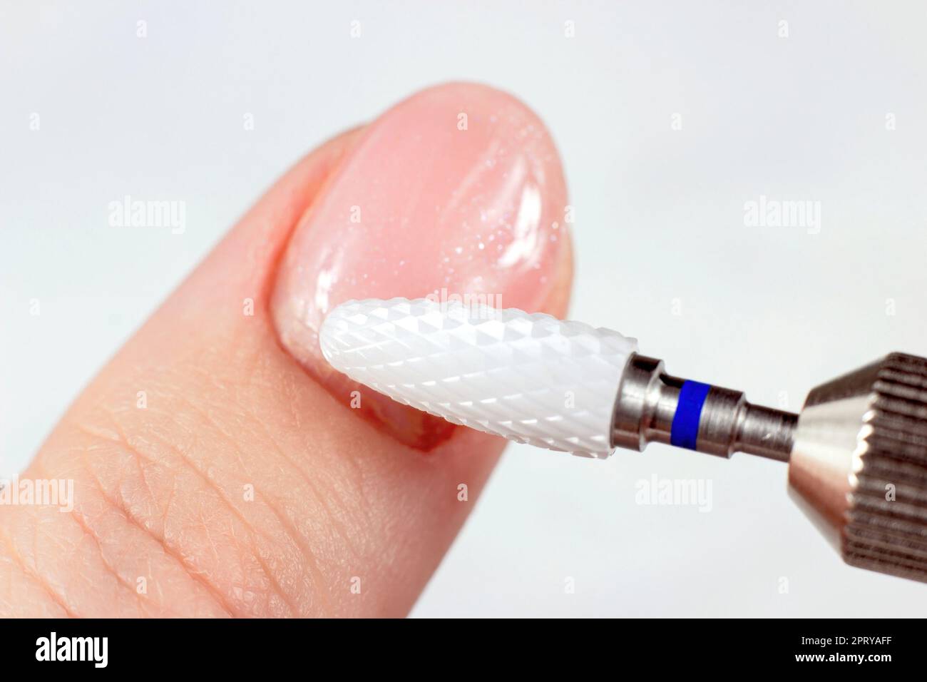 Woman hands making self manicure removing pink gel nail polish at home ...